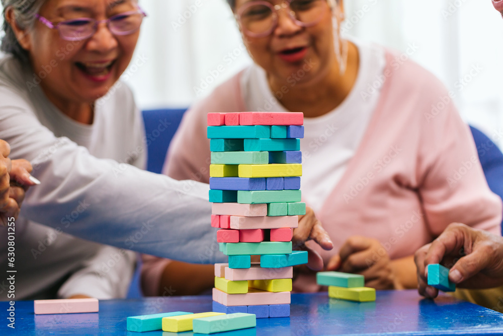 Senior people playing a wooden block tower, risk and strategy of ...