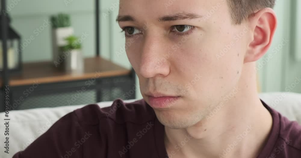Close-up portrait of a sad Caucasian man is captured sitting on the ...