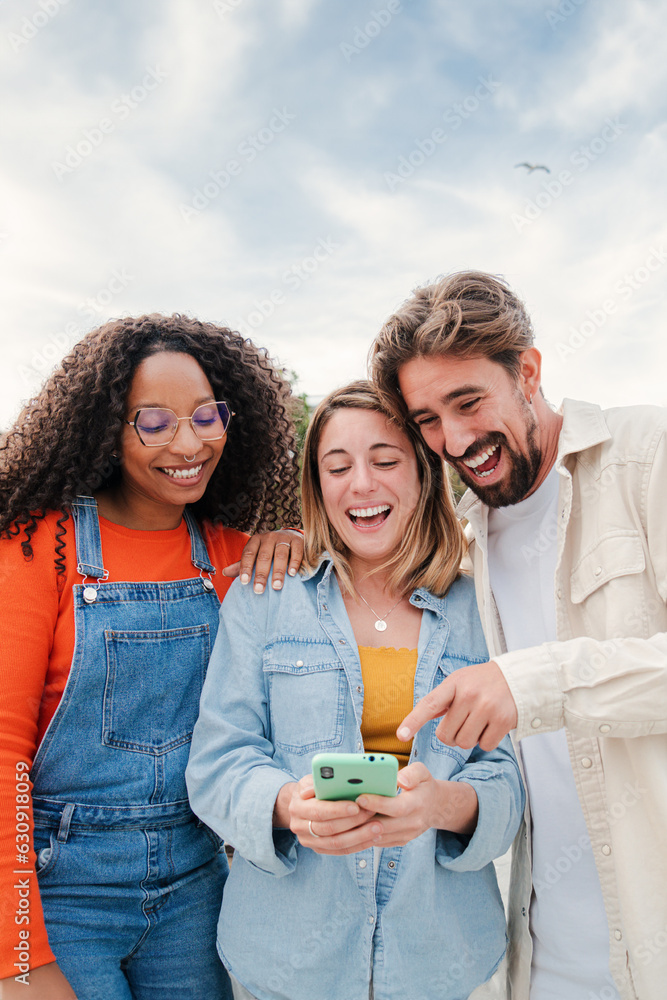 Vertical portrait of group of friends having fun with a mobile phone ...
