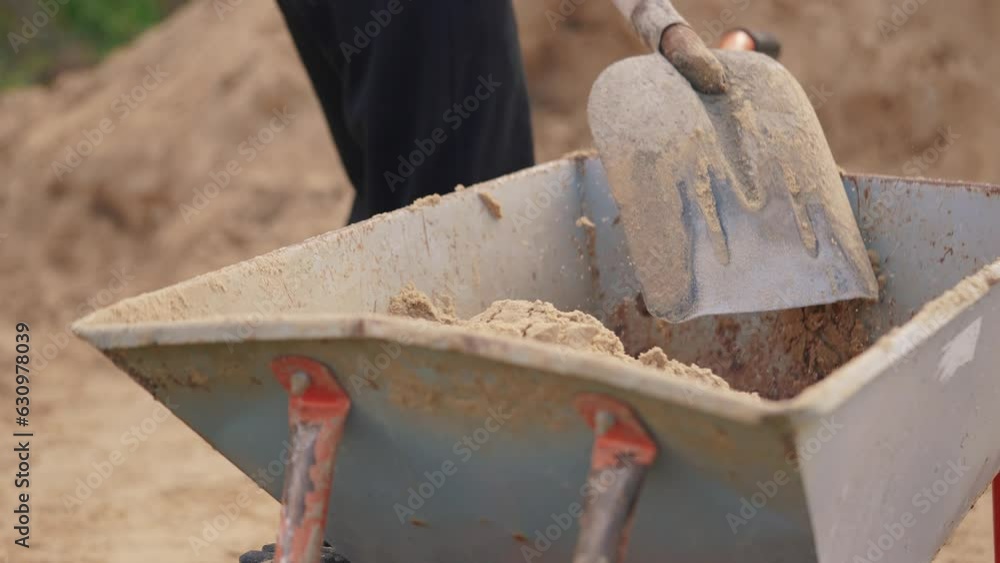 wheelbarrow for transportation of sand close-up. construction workers ...