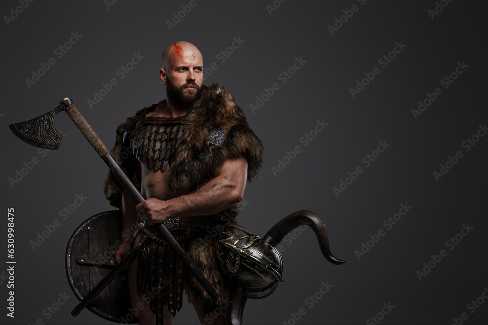 An intimidating, bald, bearded Viking donning fur and lightweight armor ...