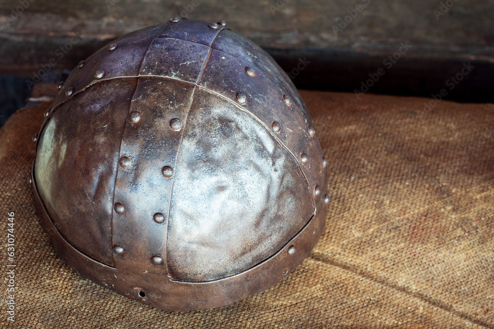 Old medieval helmet on display in blacksmith shop in a museum display ...