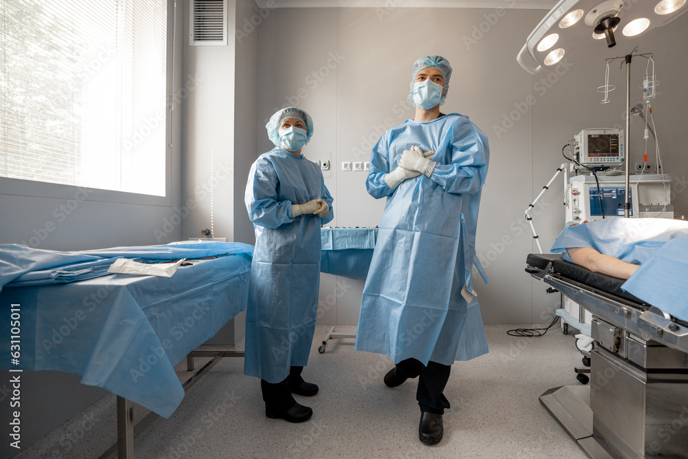 Nurse with surgeon preparing for an operation, wearing sterile uniform ...