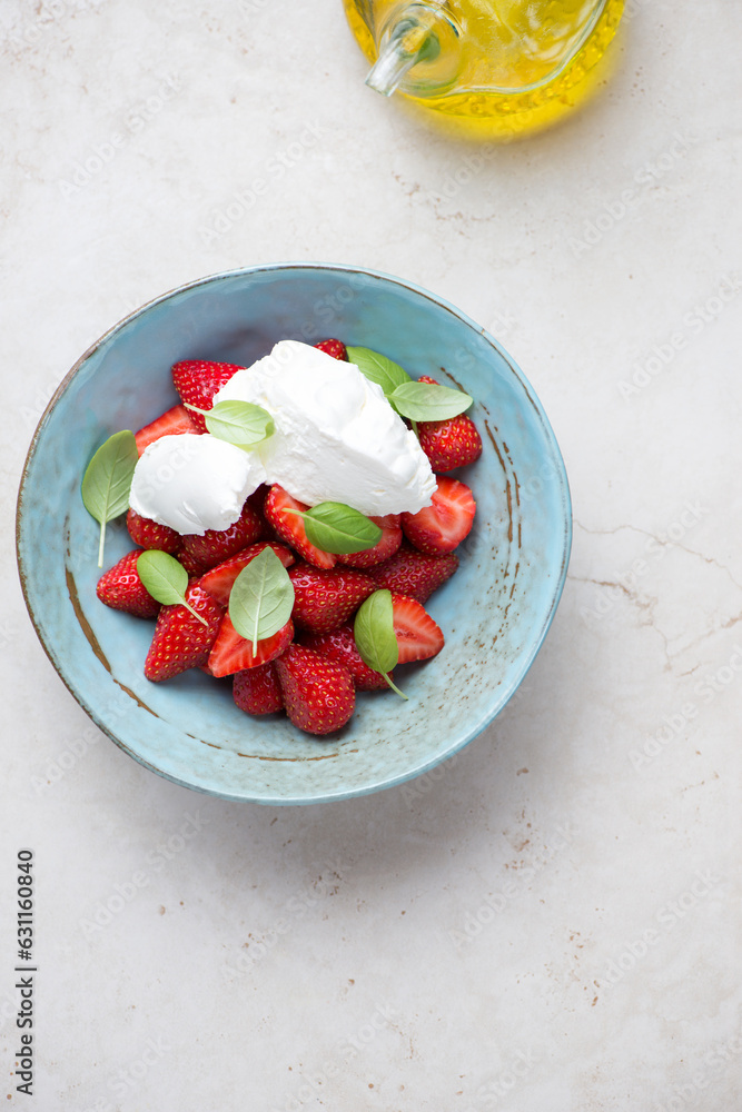 Turquoise bowl with fresh strawberries, mascarpone and green basil ...