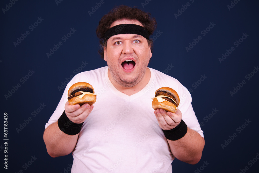Funny hungry fat man eating burger. Stock Photo | Adobe Stock