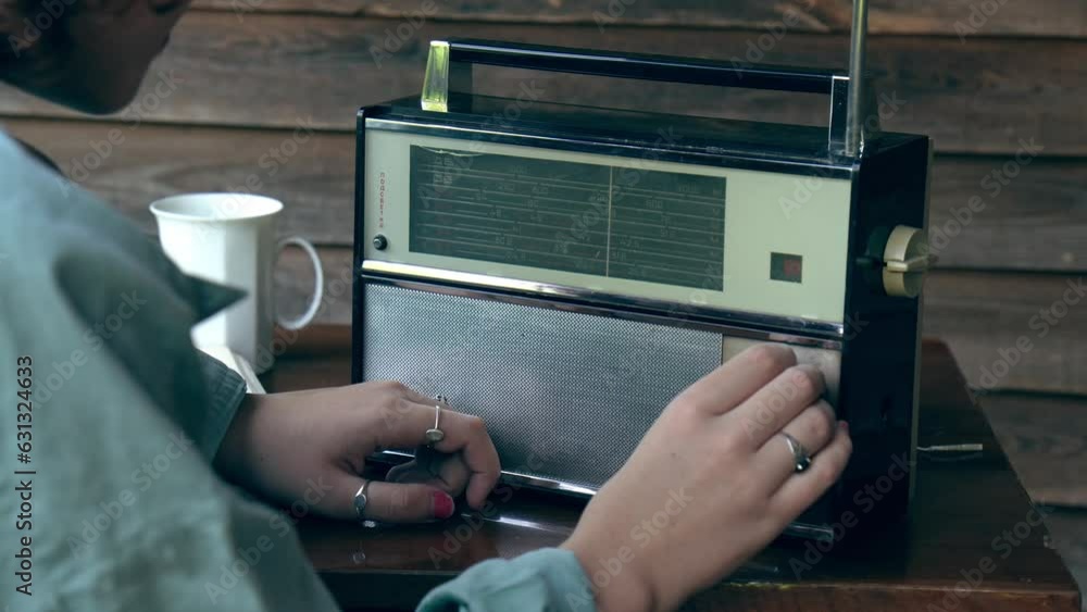 Girl searching for a radio station frequency or wave on a vintage radio ...