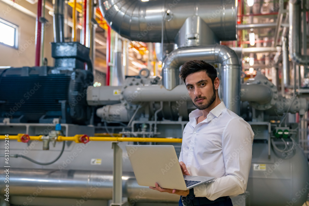 Professional male electrical engineer working on laptop computer at ...