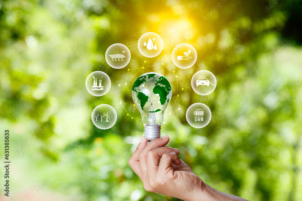 green energy concept. world icon in light bulb on hands with green ...
