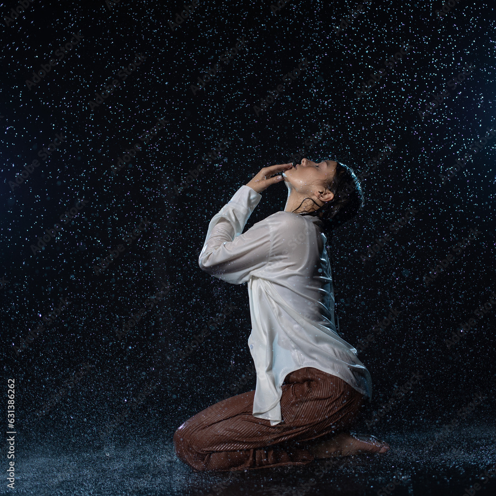 young woman in the rain, getting wet through, wet clothes and water ...