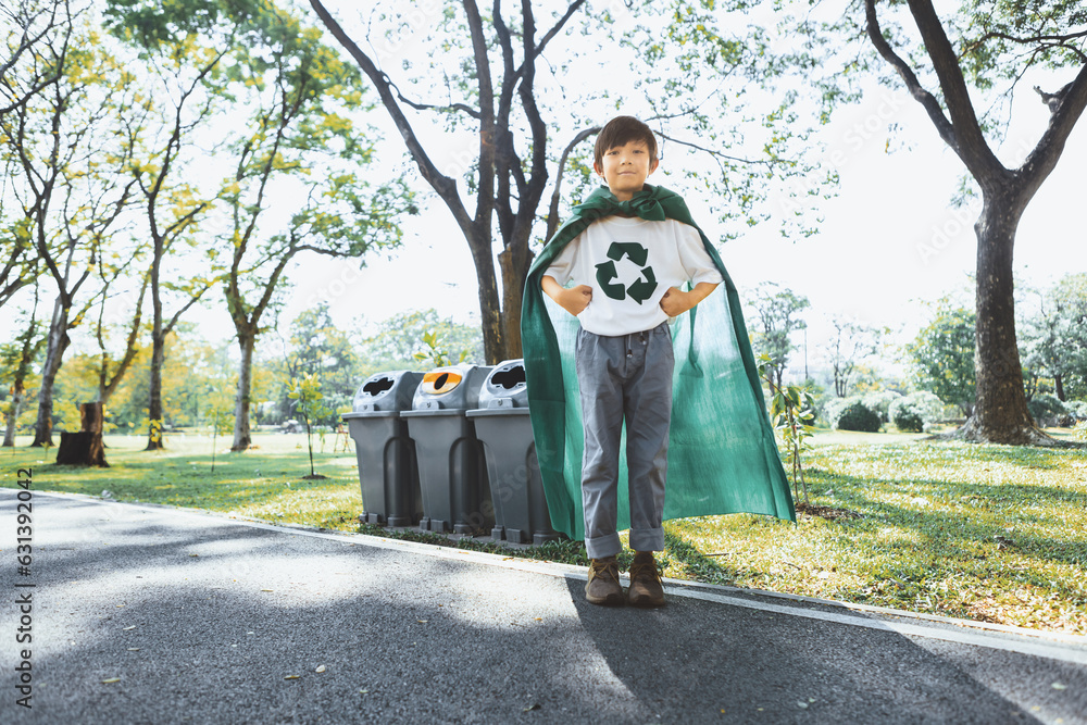 Fotka „Cheerful young superhero boy with cape and recycle symbol ...
