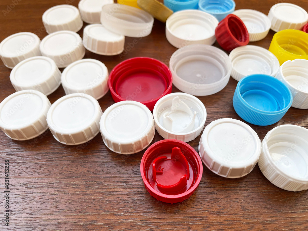 Round plastic caps of different colors and sizes lie in one pile on a ...