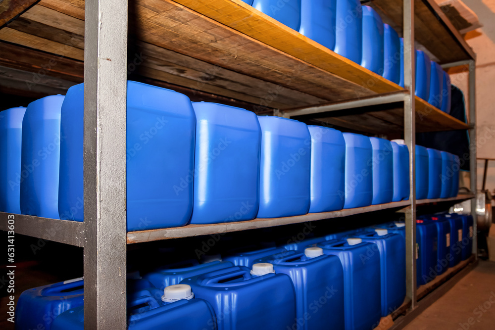 Rows liquid blue containers on racks in industrial warehouse storage of ...