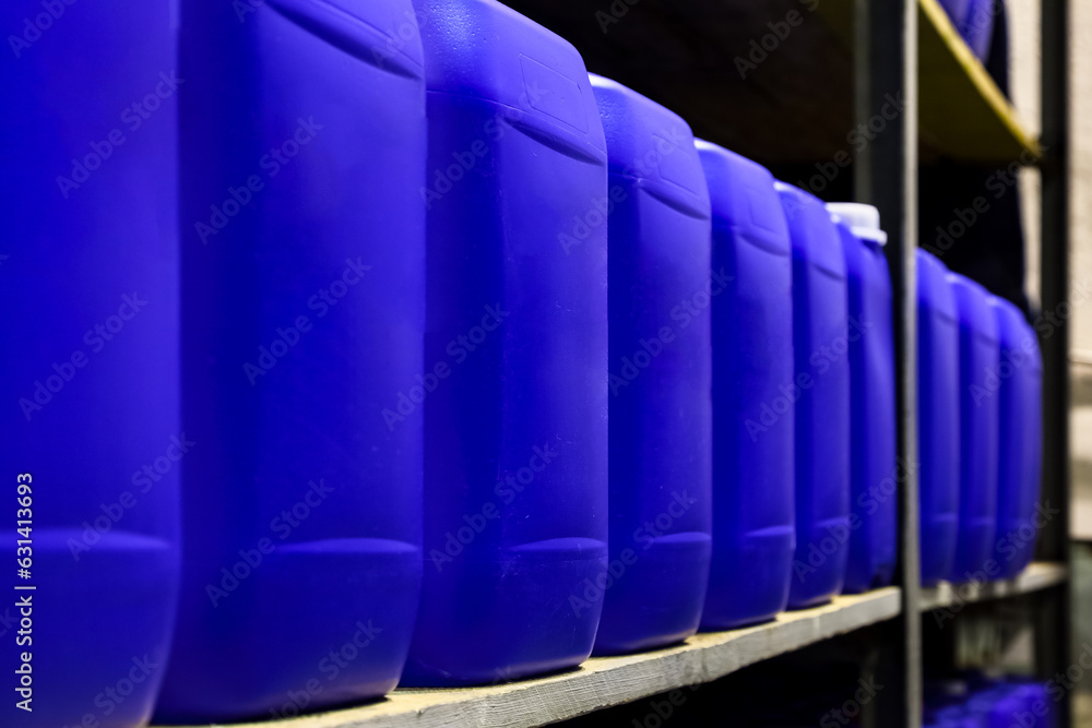 Close-up of rows liquid blue containers on rack in warehouse storage of ...