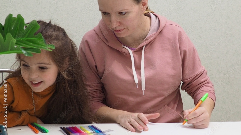 Little girl taking online art class with mother helping her at home ...