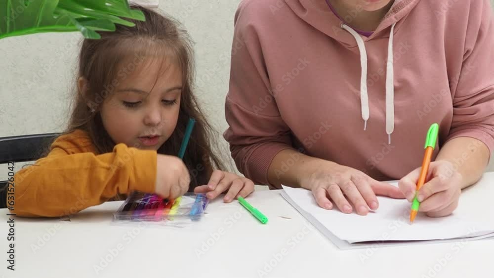 Vidéo Stock Little girl taking online art class with mother helping her ...