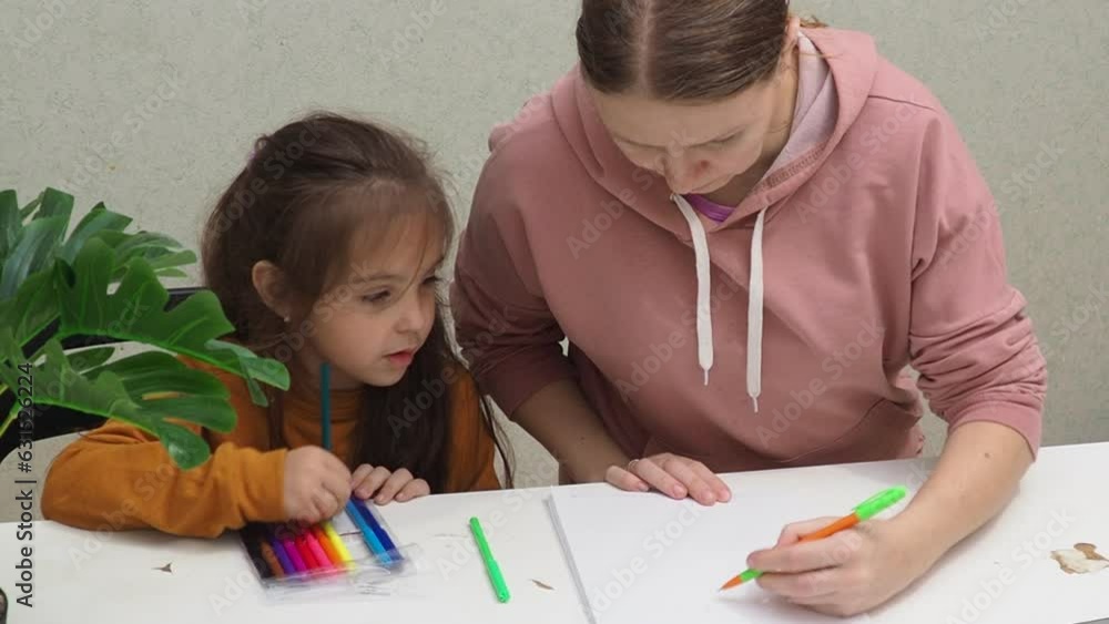 Little girl taking online art class with mother helping her at home ...