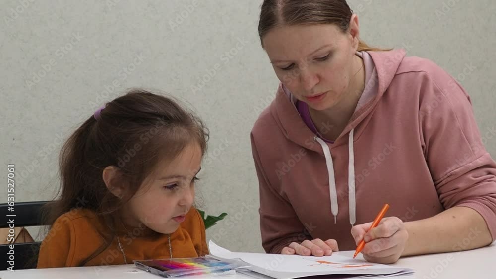 Little girl taking online art class with mother helping her at home ...