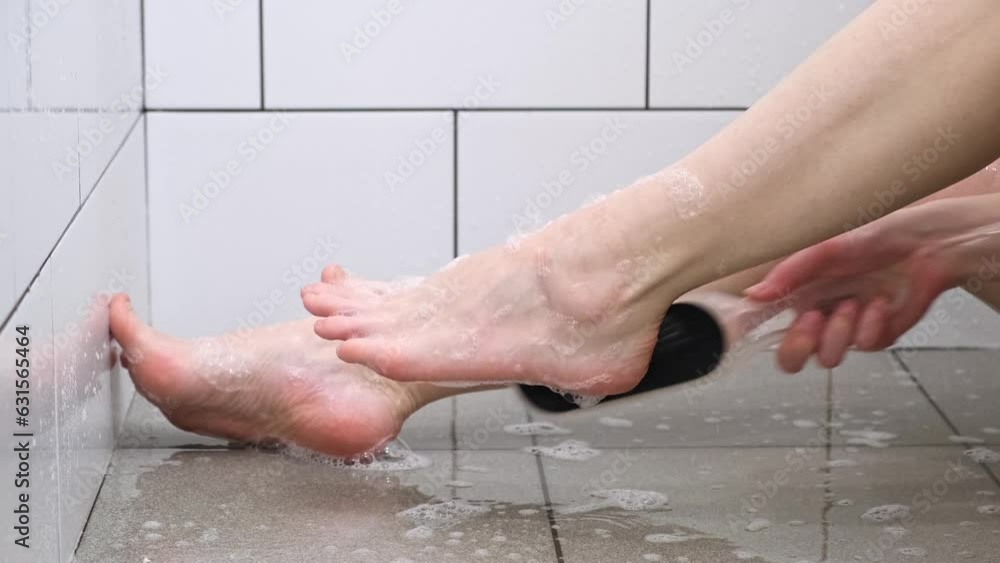 Closeup of unrecognizable woman washing feet rubbing sole of foot ...