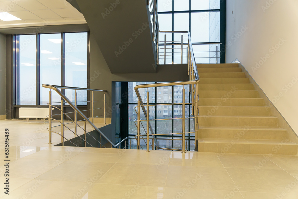 Stairwell in a modern building. An empty spacious hall with a flight of ...