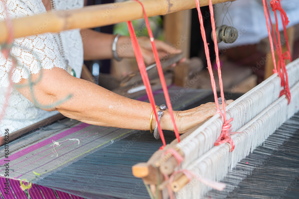 Traditional Isan Thai silk weaving. Older women hand weaving silk in ...