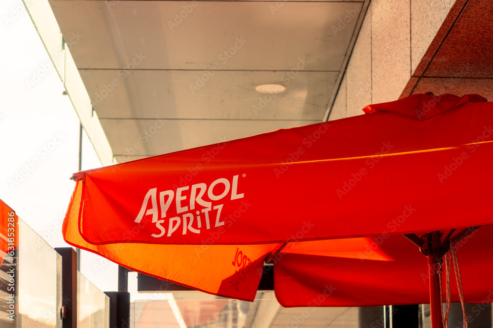 Foto de Aperol Spritz parasol with large logo backlit on a terrace at a ...