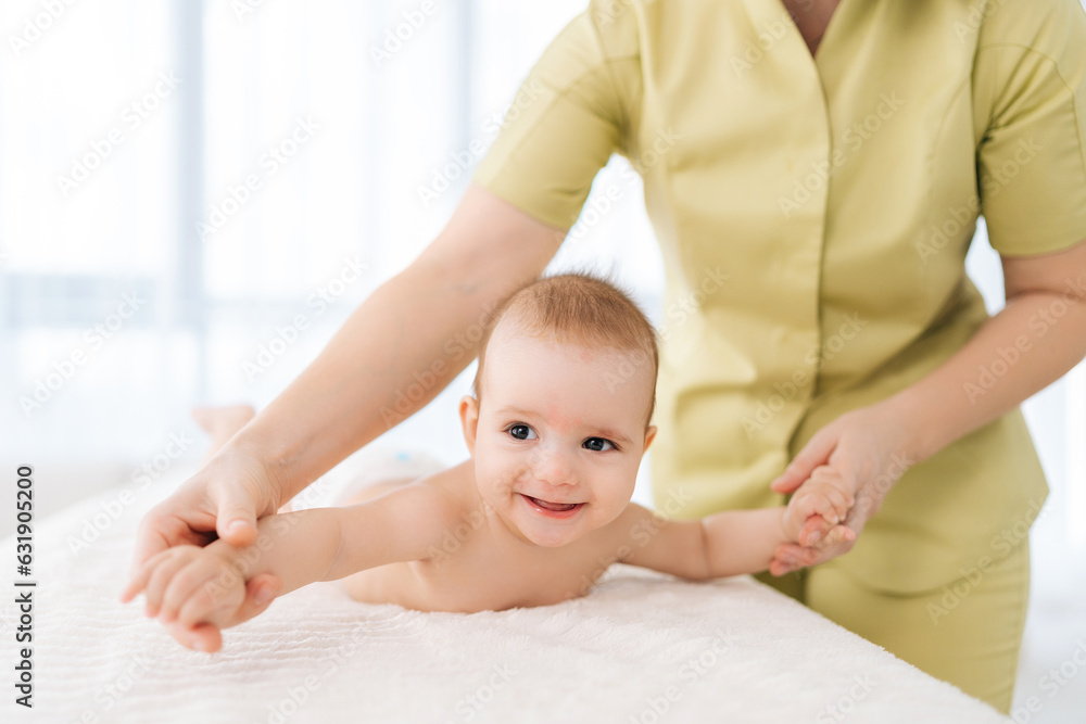 Cropped shot of unrecognizable pediatric masseur with cute baby boy doing exercise simple ...