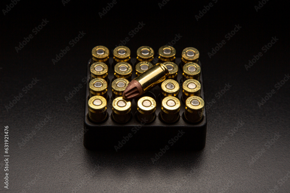 Pistol cartridges 9 mm on a smooth glossy surface with reflections ...