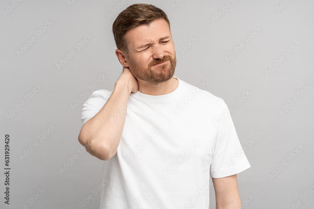 Frustrated man with muscle ache injury have pain in nape. Upset frown ...