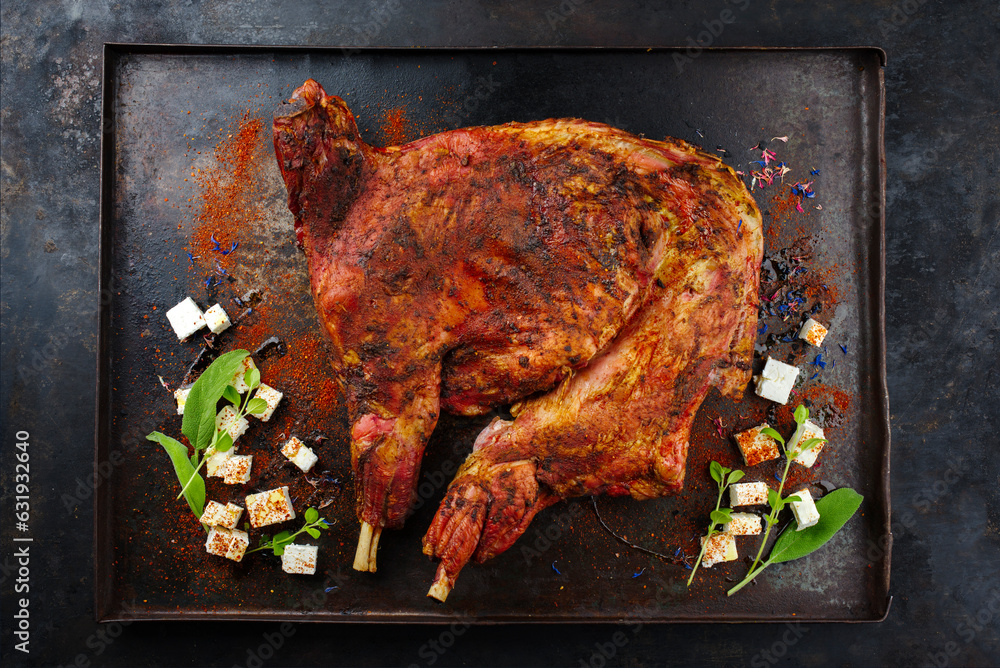 Traditional barbecue half of dairy goat with shoulder and leg served as ...