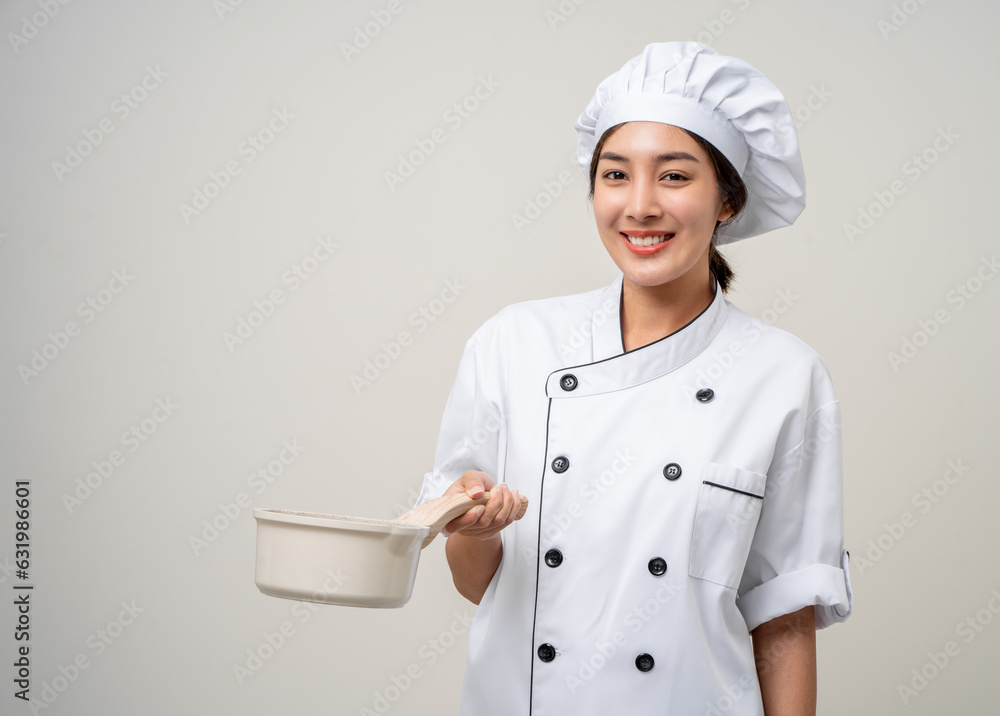 Young beautiful asian woman chef in uniform holding soup pot ladle ...