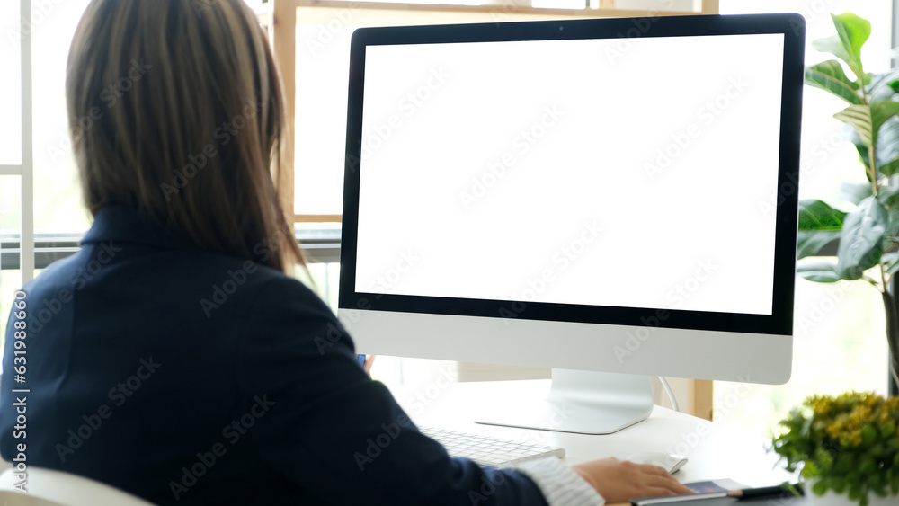 Woman using desktop computer with blank screen for mock up template ...
