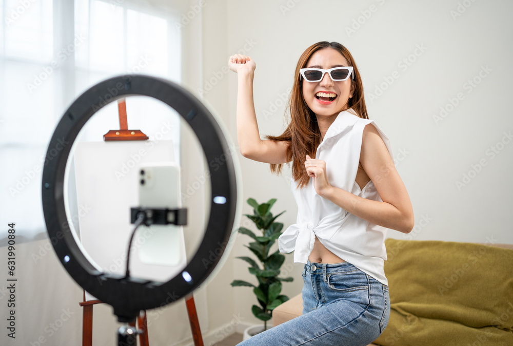 Young trendy influencer asian woman dancing on mobile phone at home in ...