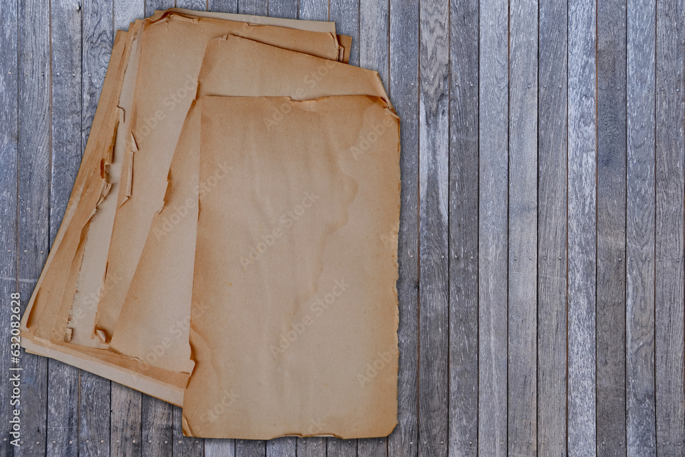 Closeup wooden desk with stack of old paper torn off edges for message ...