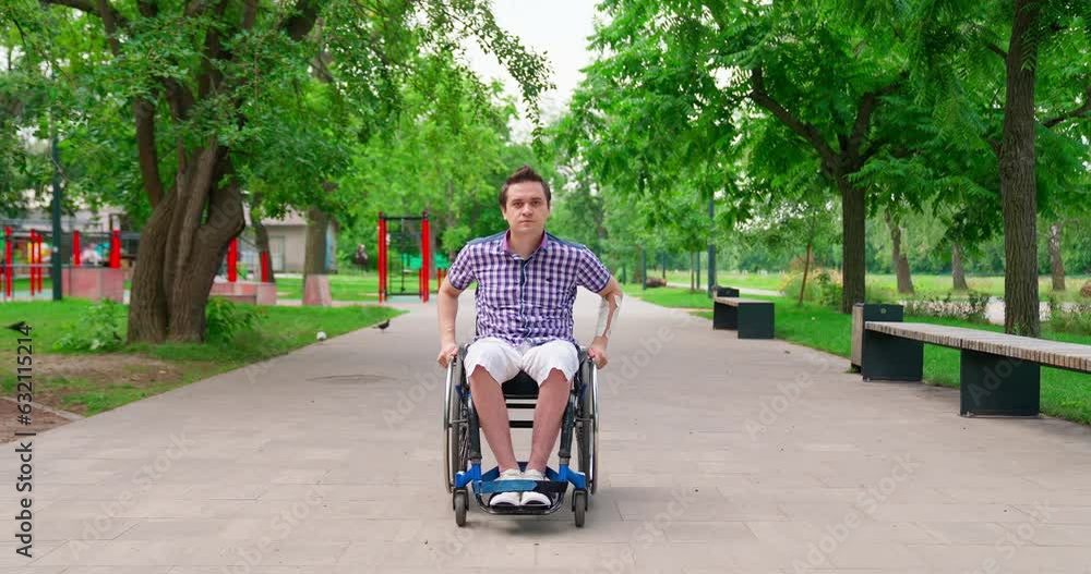 A man in a wheelchair rides in the park. A disabled person plays tennis ...