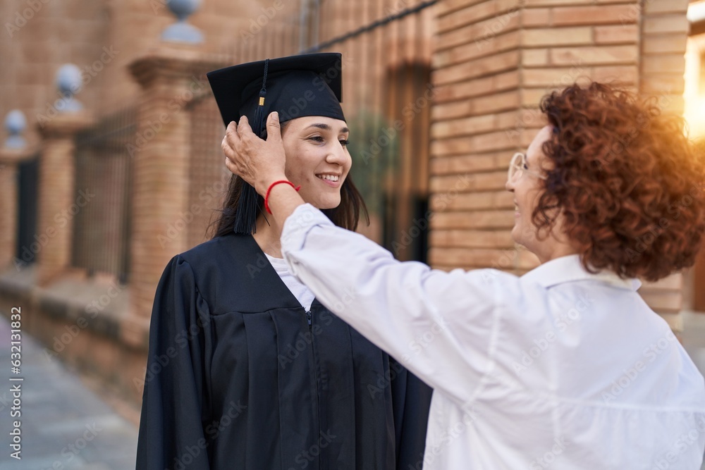 Two women mother and daughter celebrating graduation at campus ...