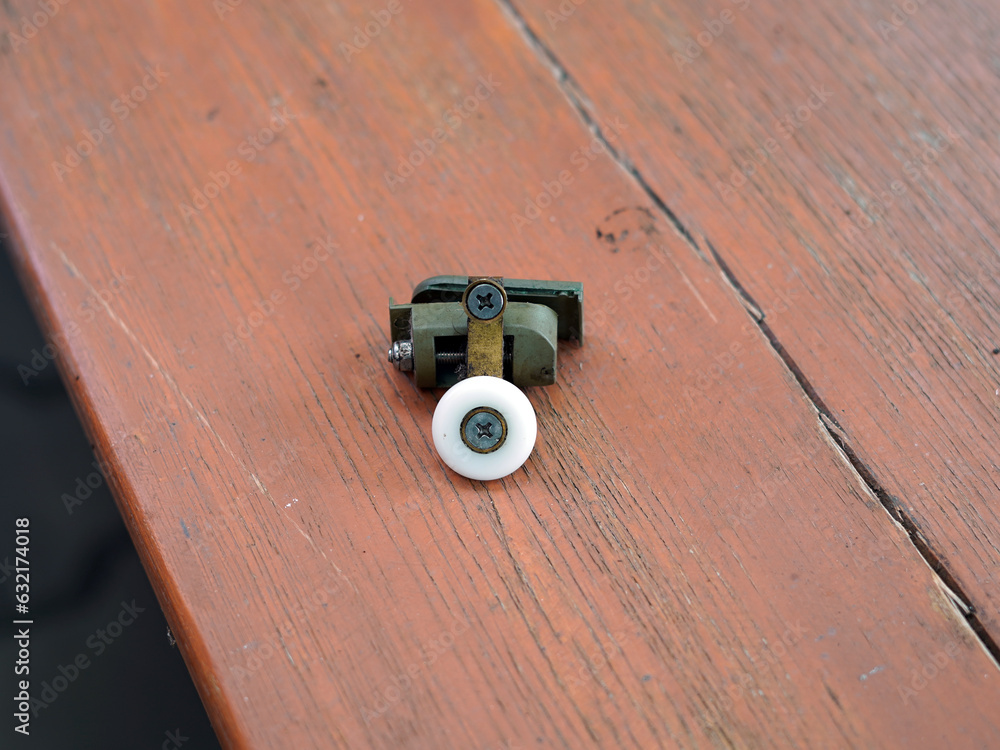 Caster with locking mechanism. Part of the sliding door from the shower ...