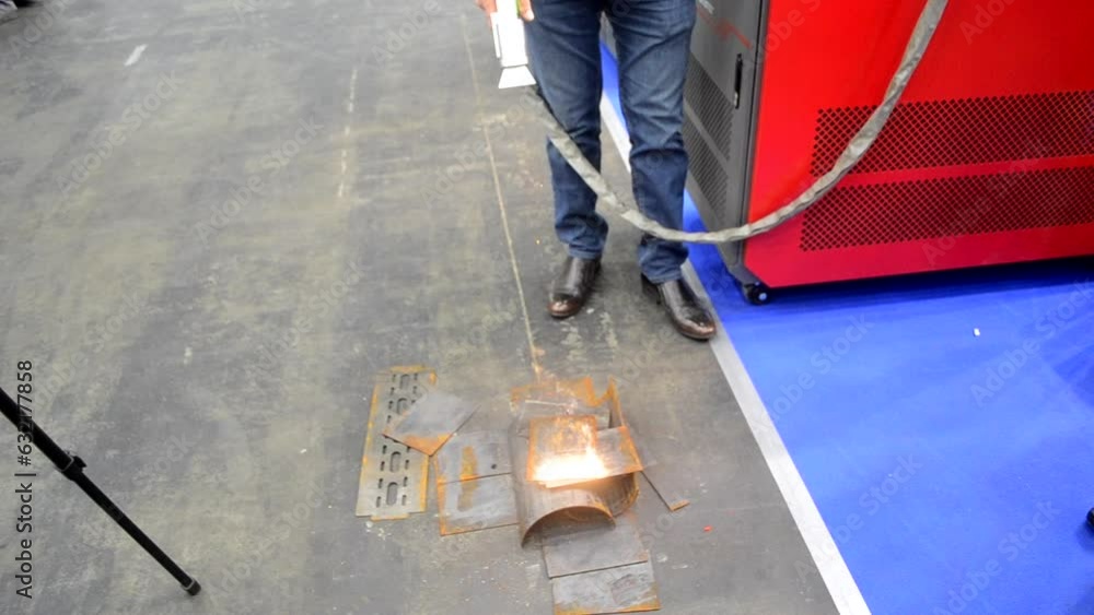 Process of laser cleaning of metal surfaces. Man cleaning surface from ...