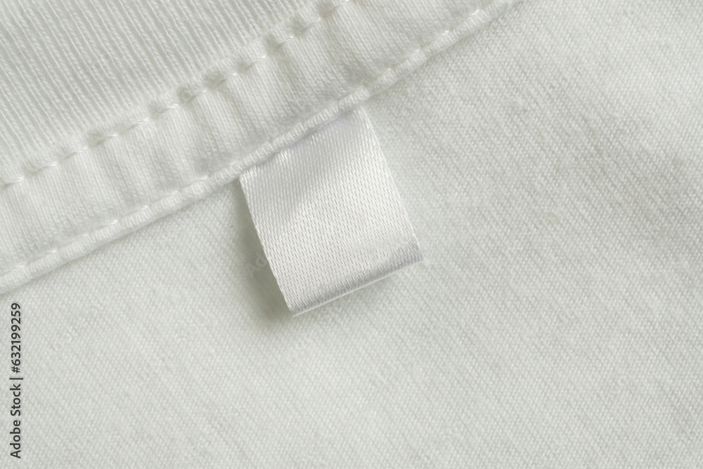 Blank white laundry care clothes label on white shirt fabric texture ...