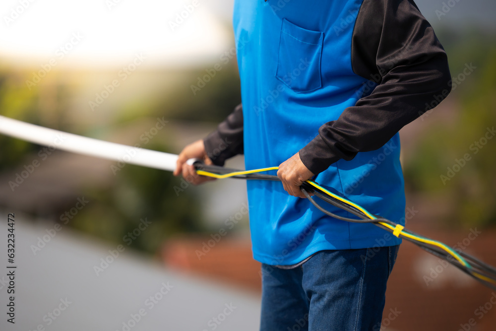 Close up hand man worker. Electrician male pulling wire into PVC pipe ...