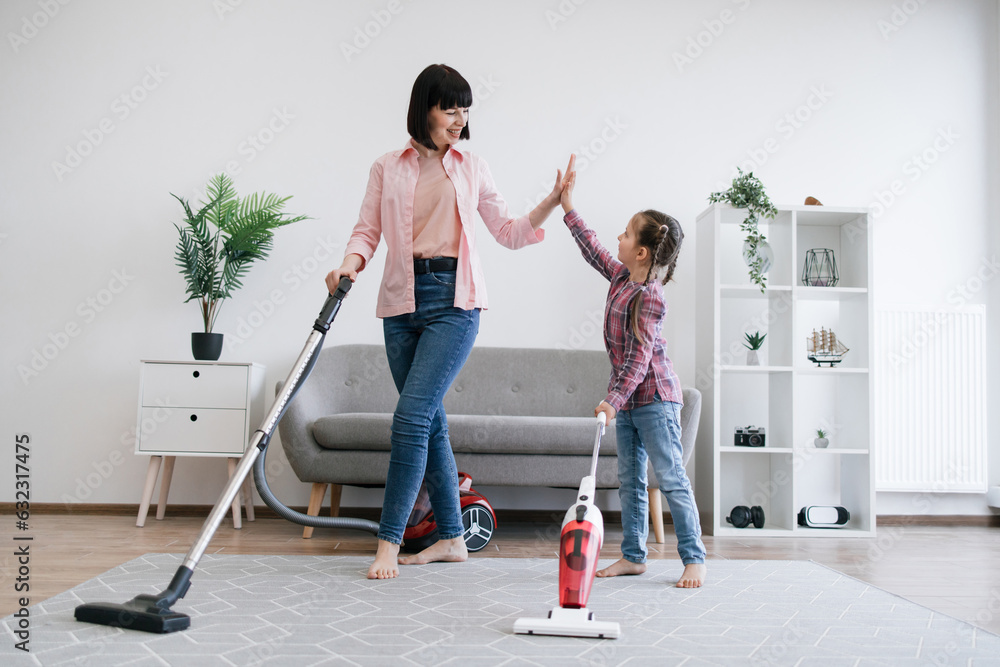 Friendly woman and tween child giving high five to each other while ...
