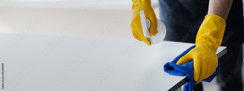 Person cleaning the room, cleaning staff is using cloth and spraying ...