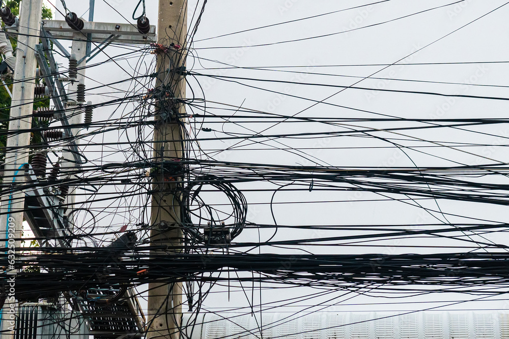 Messy wires attached to the electric mast. chaos of cables and wires on ...