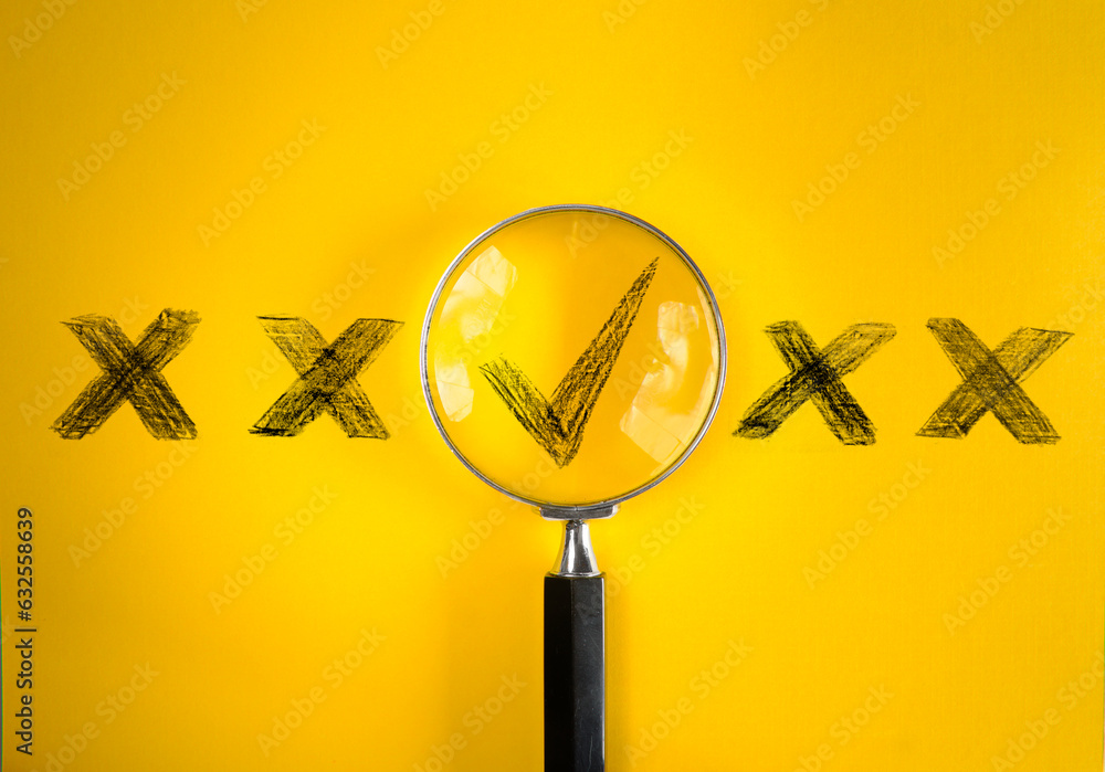 Magnifier enlarging the correct choice or check mark on yellow ...