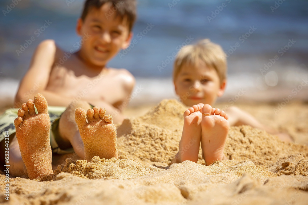 Child, tickling sibling on the beach on the feet with feather, kid ...