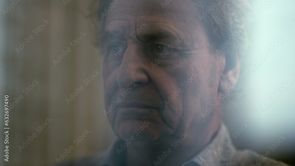 One serious older man seen thinking about life, seen through window ...