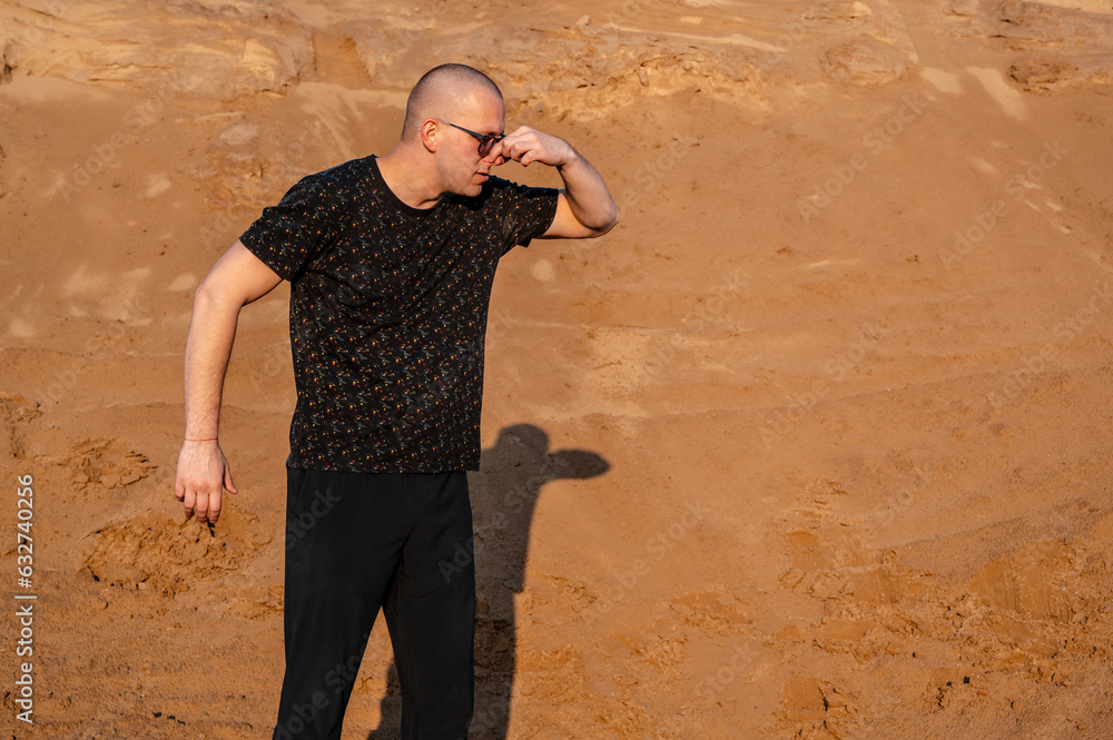 Short hair man on natural sand smelling something stinky and disgusting ...