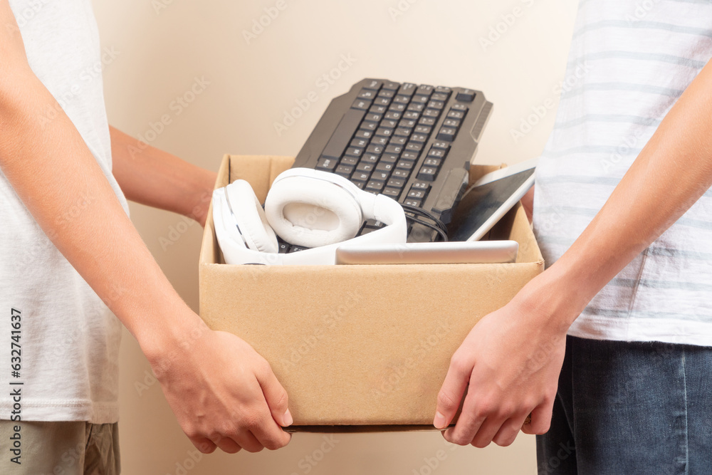 Volunteer hands holding donation box with used technology gadgets to ...