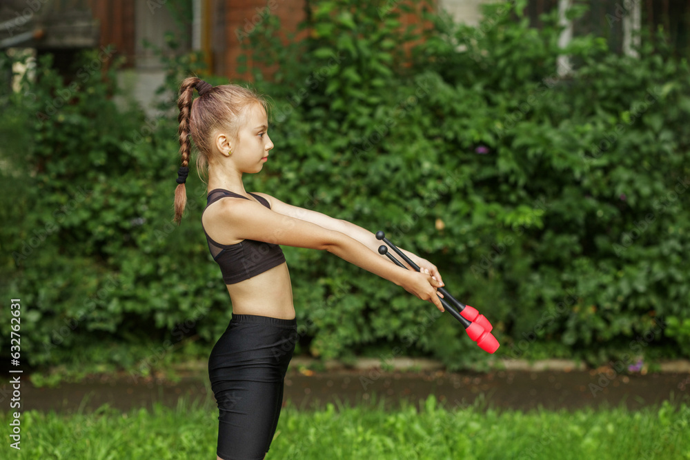 Rhythmic gymnastics. Preteen child exercising with gymnastic mace ...