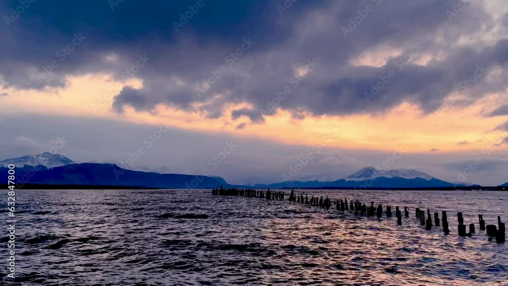Calm sunset scene of the Ocean waves and snowed mountains peaks in ...