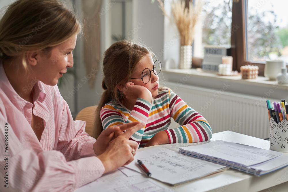 Distracted girl learning at home with her mother Stock Photo | Adobe Stock
